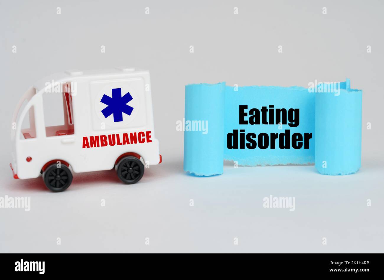 Medical concept. On a white surface, an ambulance and a blue paper sign ...