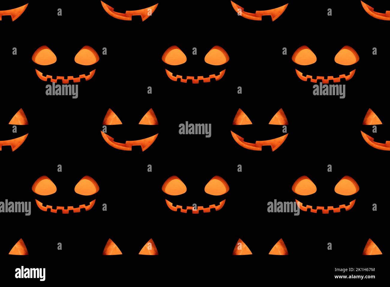 Seamless pattern with a glowing jack lantern smile on a black ...