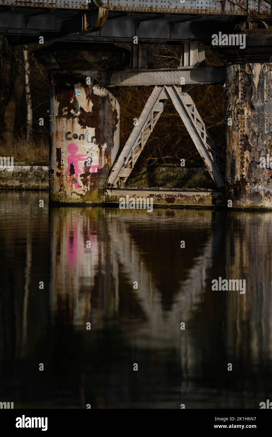 The reflection of the bridge metal columns on the water surface and ...
