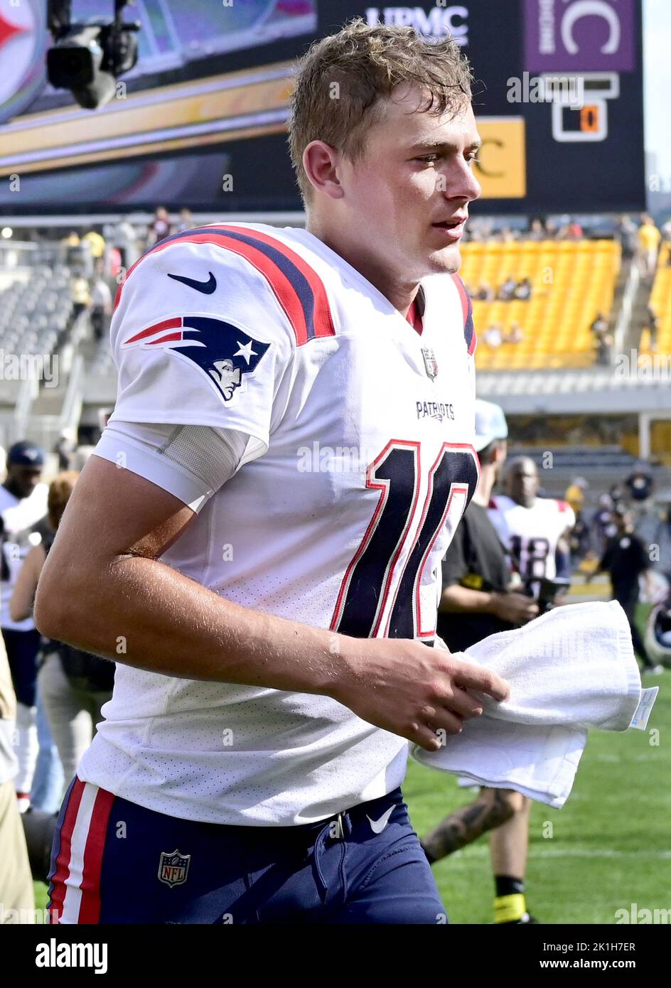 New England Patriots quarterback Mac Jones (10) runs off the field ...