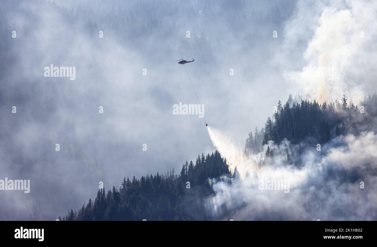 Wildfire Service Helicopter flying over BC Forest Fire and Smoke on the ...