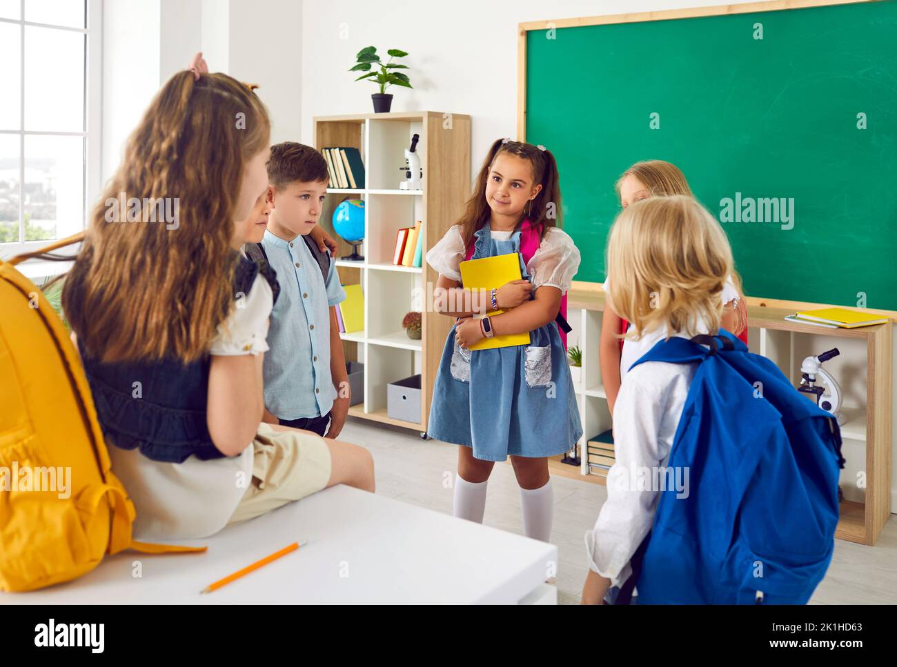 Boys and girls elementary school students talking together in school ...