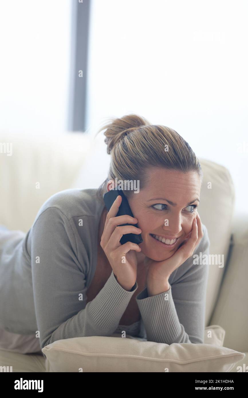 Lapping up the little luxuries in life. an attractive woman lounging on ...