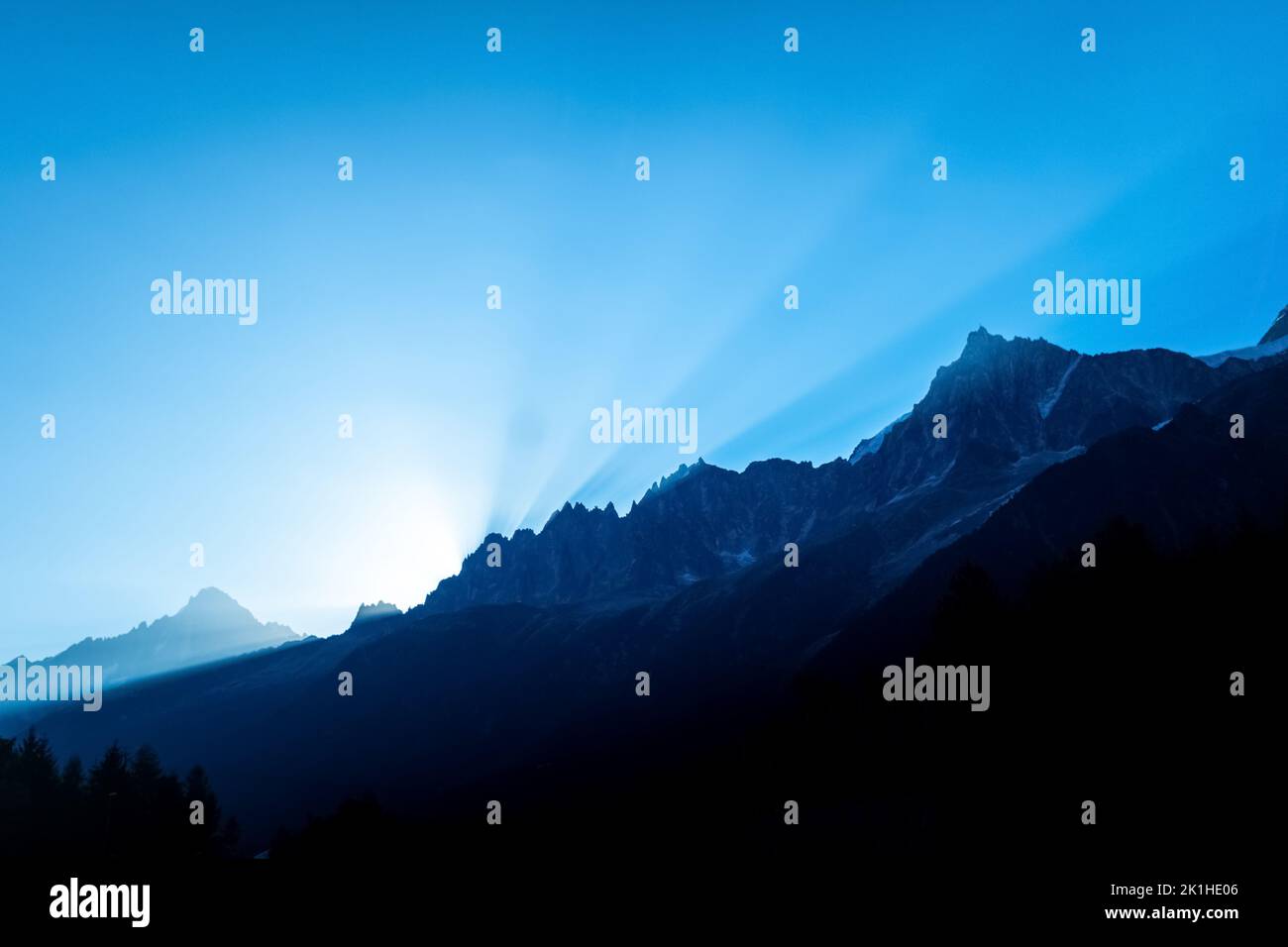First rays of sun among the alpine peaked mountains, calm nature ...