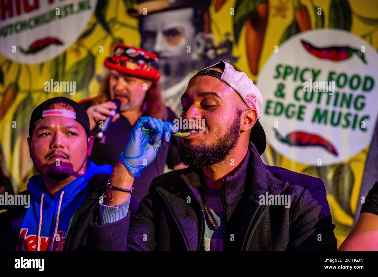 A participant watches as another eats his pepper during the Dutch Chili ...
