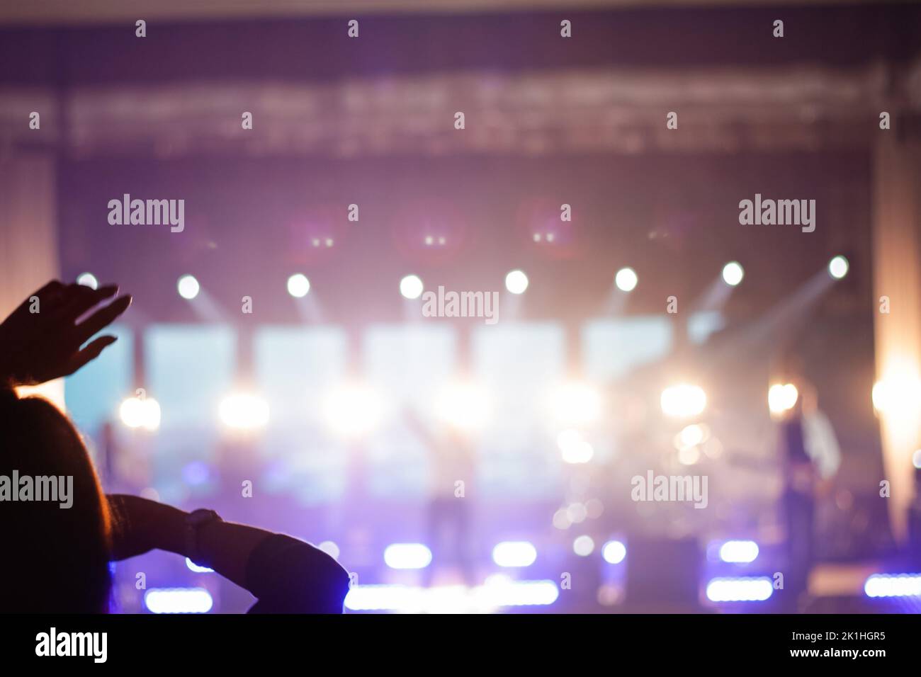 Defocus silhouette of one woman raise hand up in music concert with ...