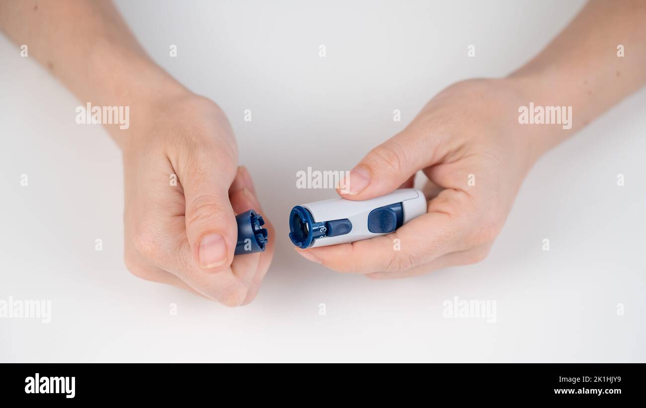 Caucasian woman inserts a needle into a lancet pen Stock Photo - Alamy