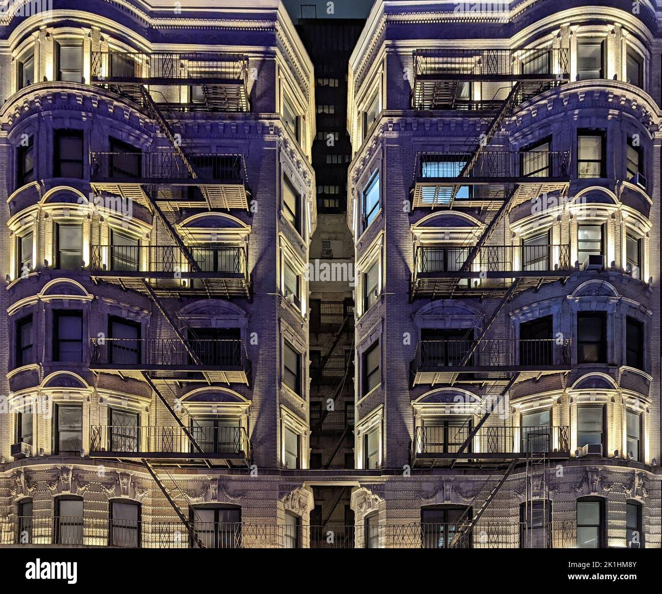 Lights shining on a old apartment building in New York City at night ...