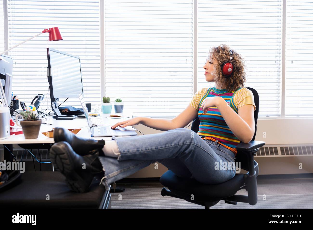 Using laptop with feet on desk hi-res stock photography and images - Alamy