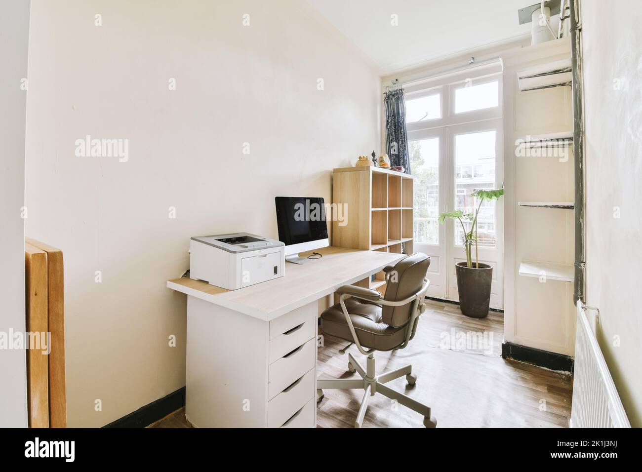 Comfortable chair placed near desk with computer monitors and ...