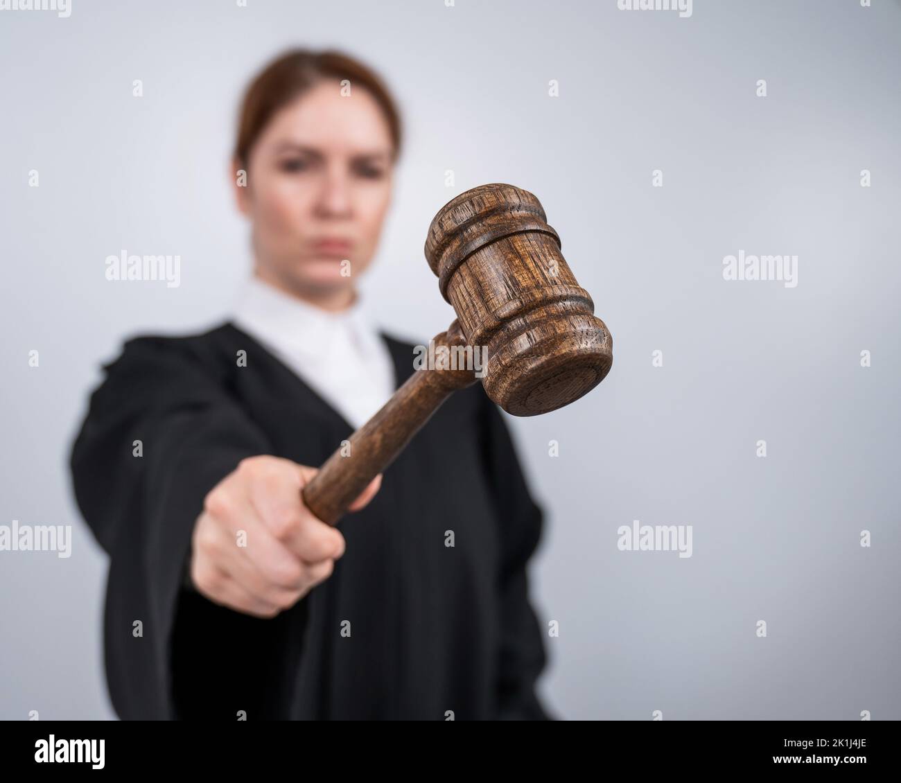 Steadfast female judge in a robe holding a court gavel Stock Photo - Alamy