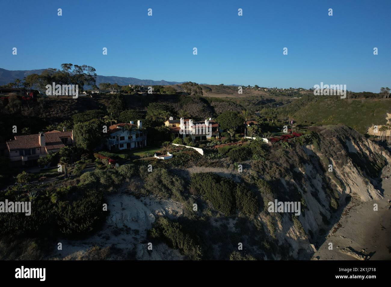 An aerial view of residential houses built on a cliff near the beach in ...