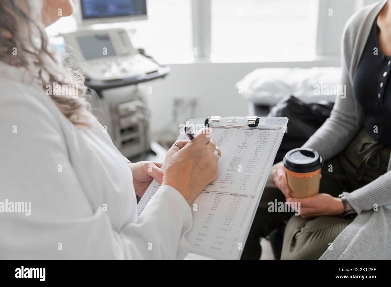Female doctor writing notes of discussion with patient Stock Photo - Alamy