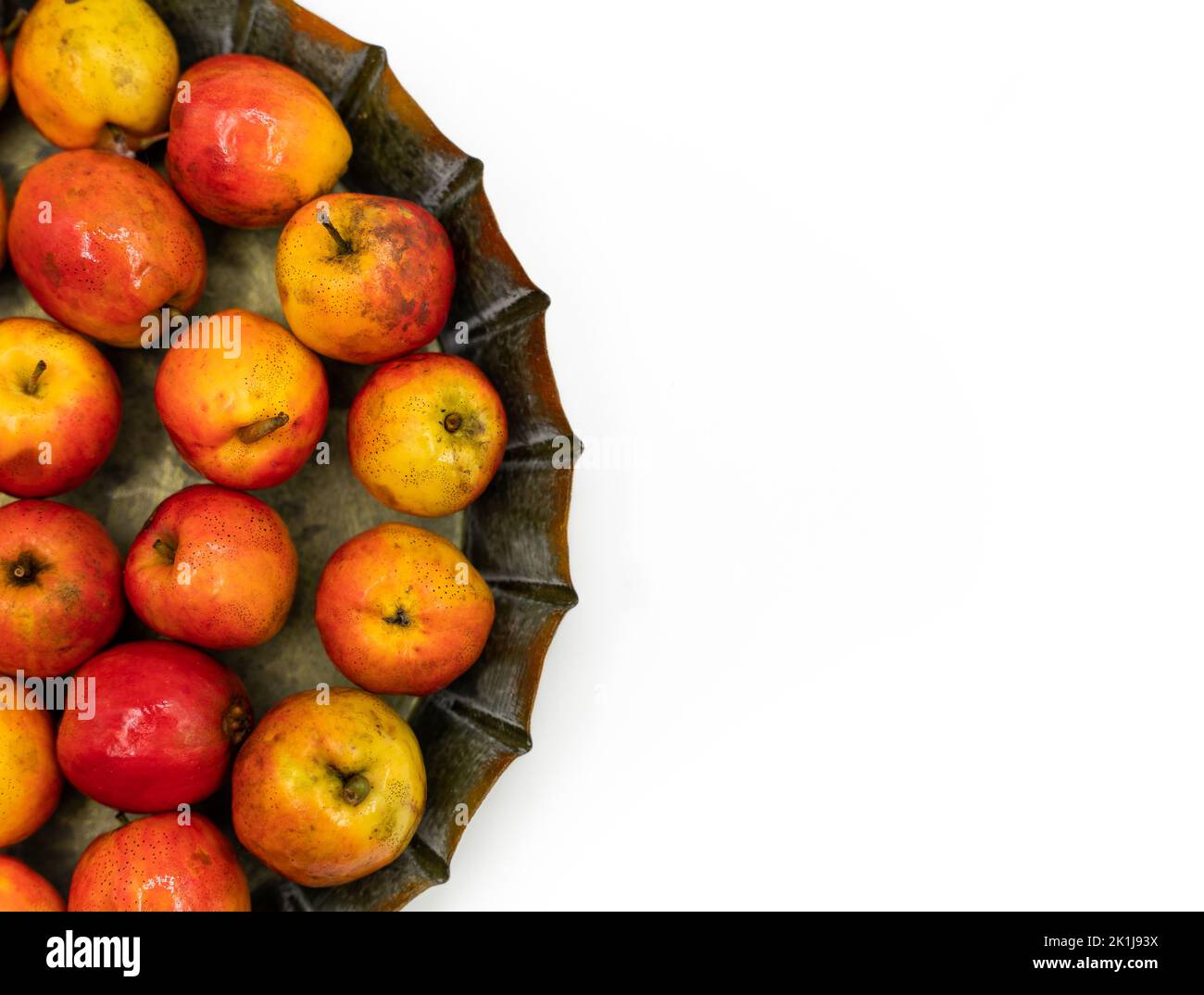 Ripe red small apples Ranetka on a metal plate, on a white background ...