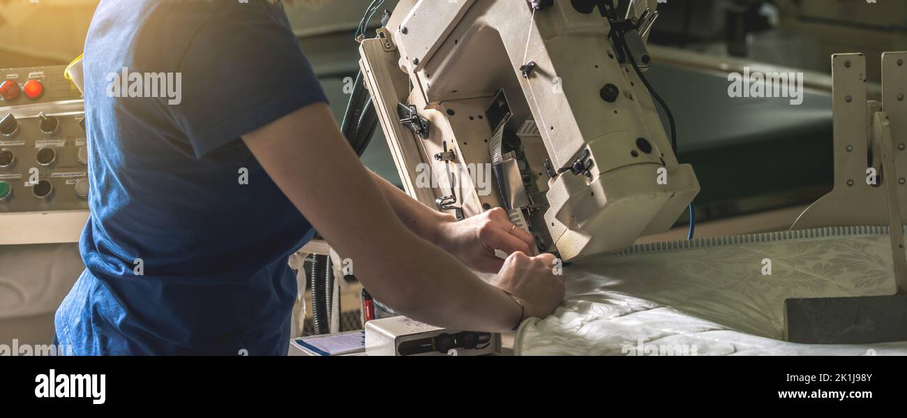 Woman in the process of sewing on professional equipment. Sewing fabric ...