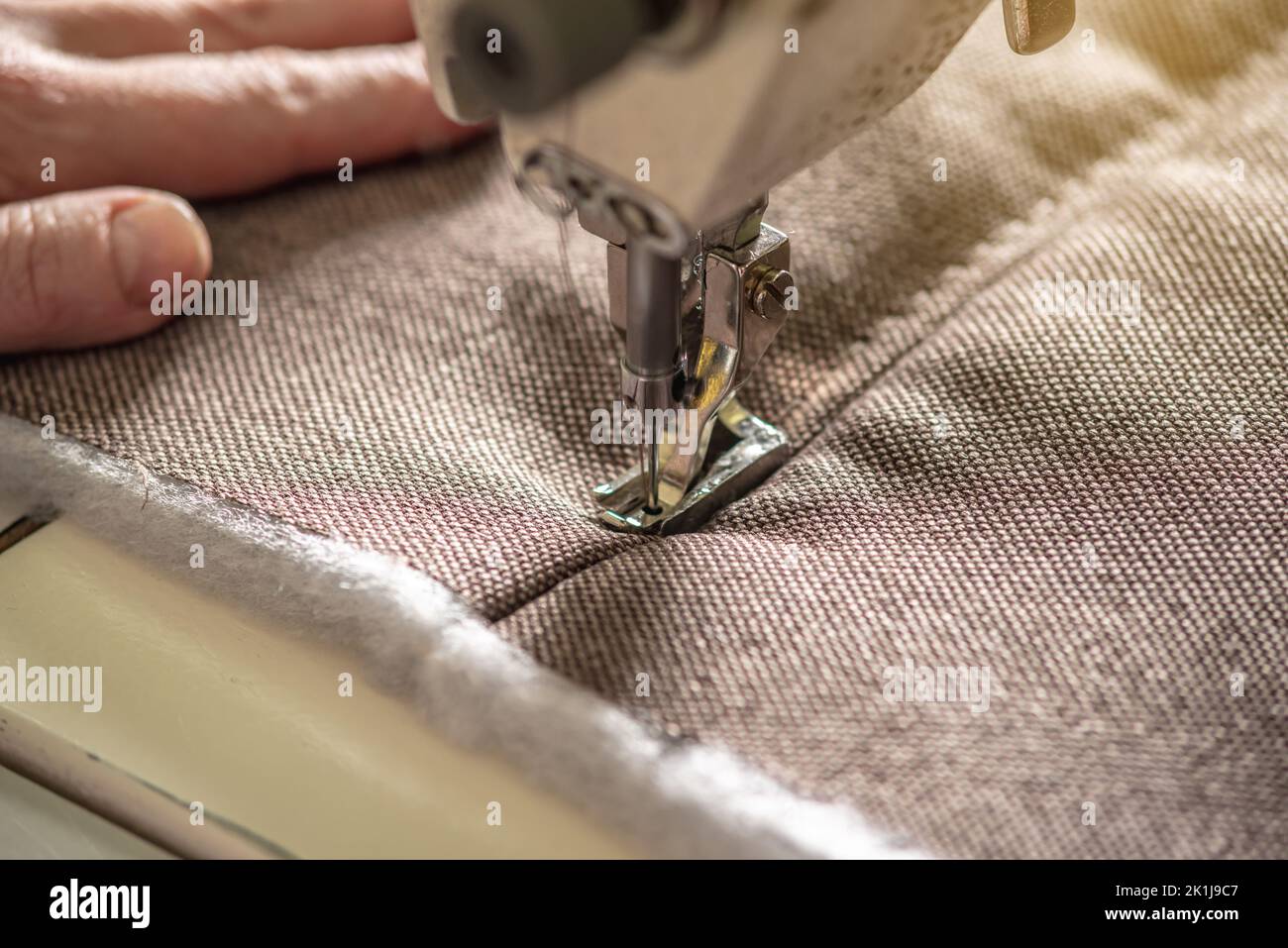 Women's hands in the process of sewing on professional equipment ...