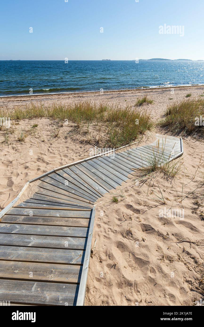 Wooden boardwalk at the empty Tulliniemi beach in Hanko, Finland, on a ...