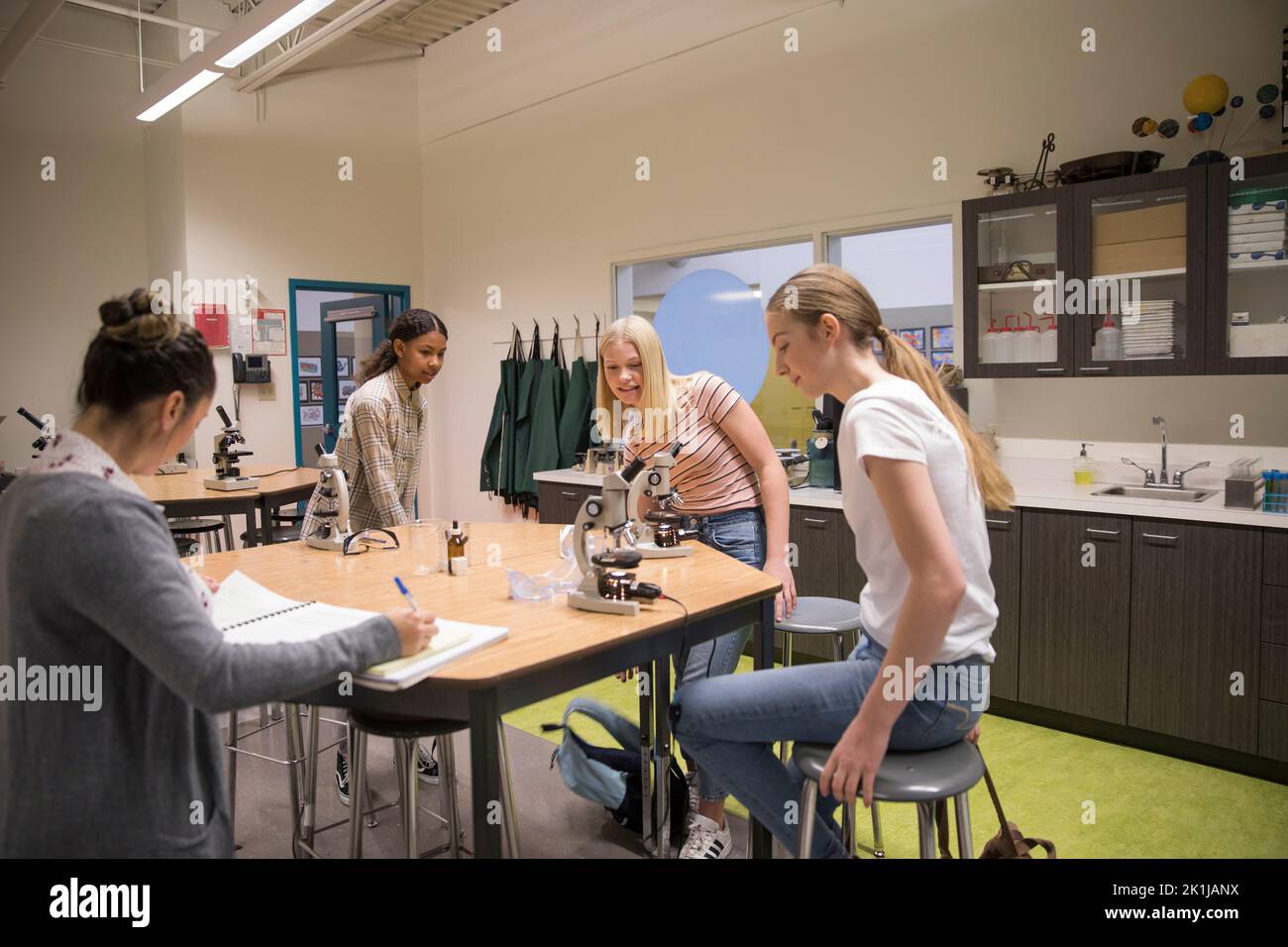 Students using a microscope in science class hi-res stock photography ...
