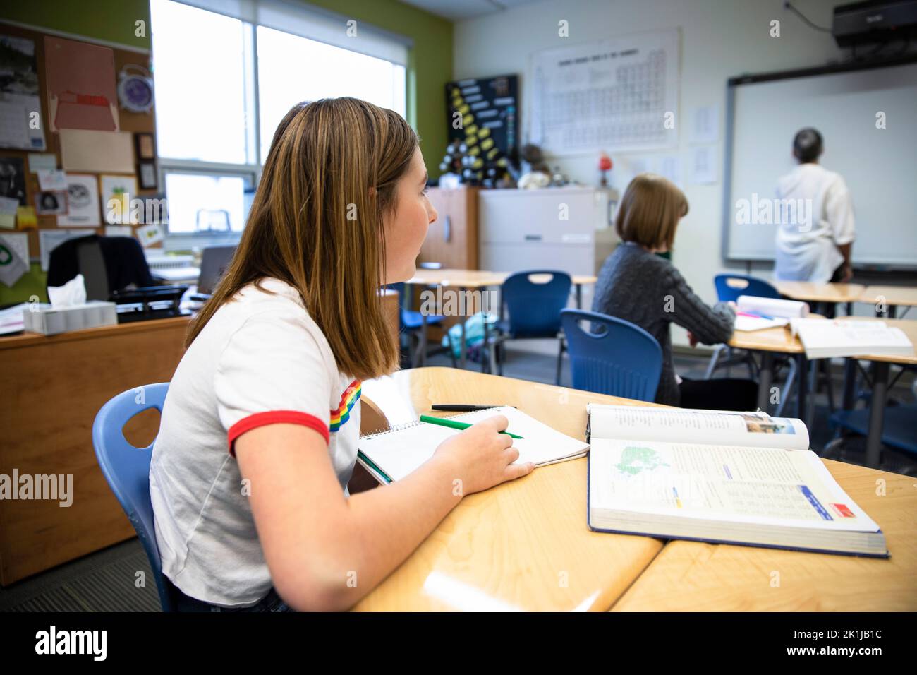 Attentive junior high girl student listening in classroom Stock Photo ...