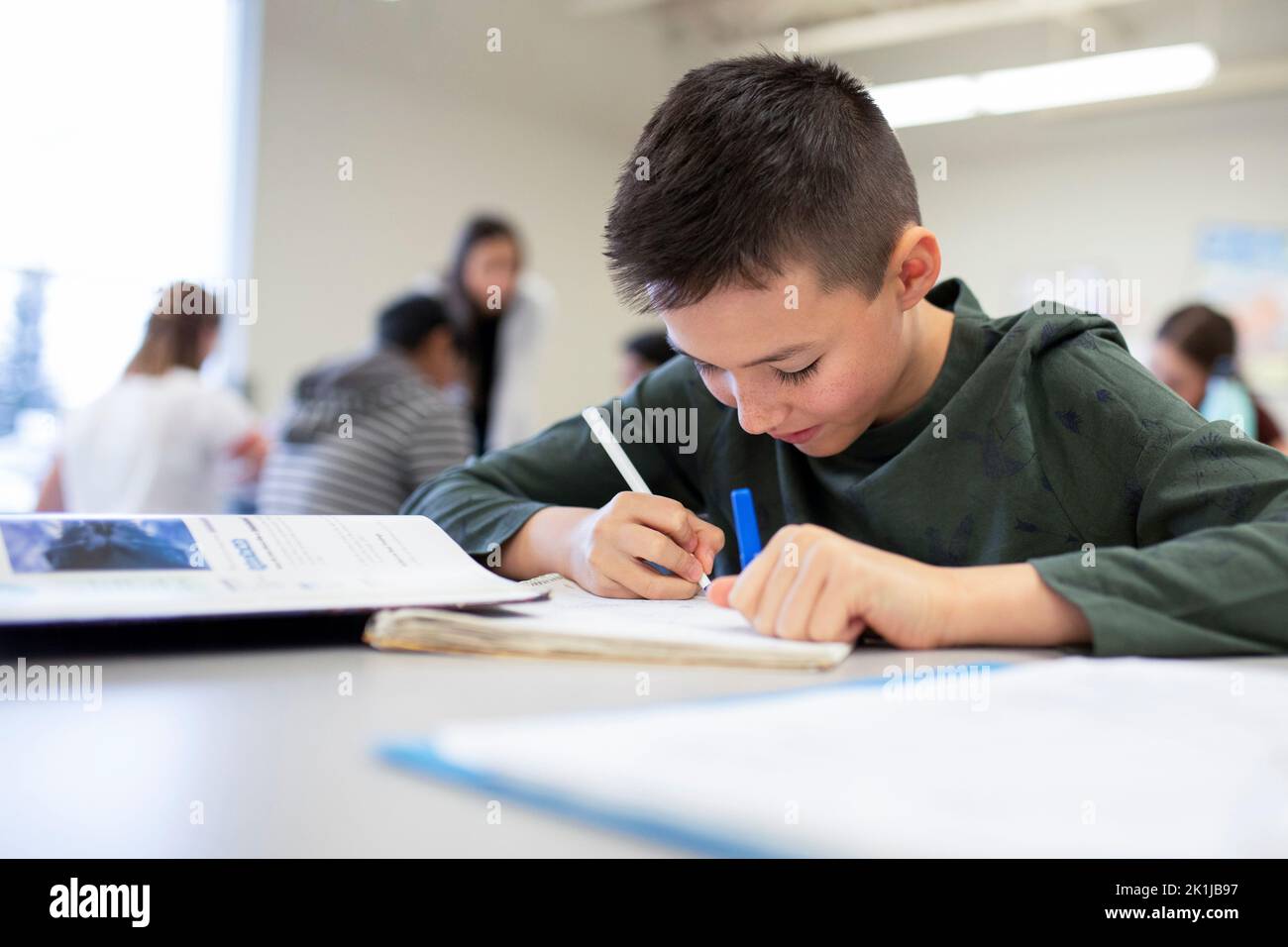 Boy in classroom writing hi-res stock photography and images - Alamy