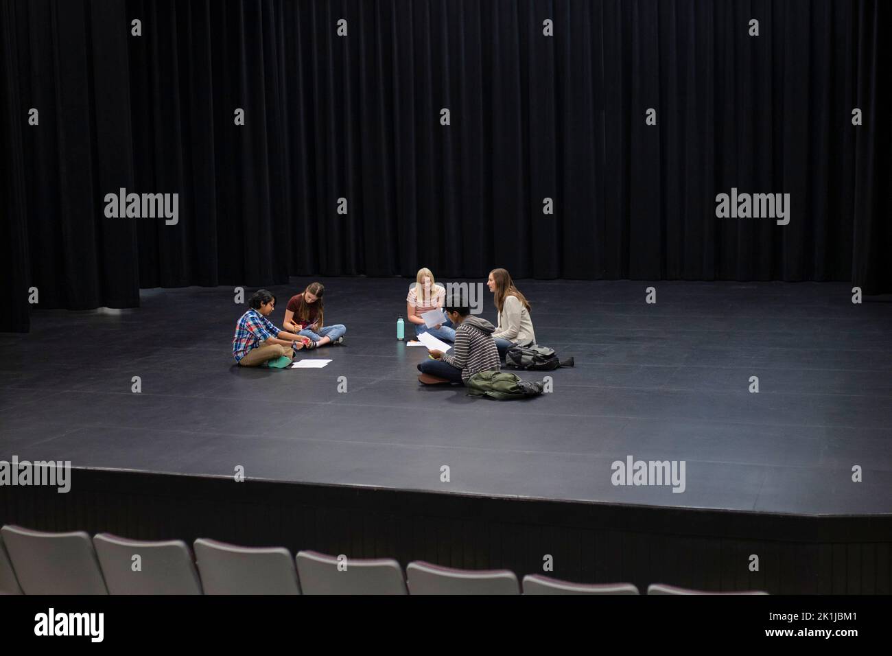Junior high students reading script on stage in drama class Stock Photo ...