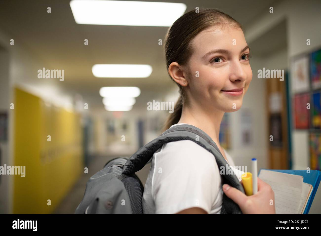 Portrait confident junior high girl student in corridor Stock Photo - Alamy