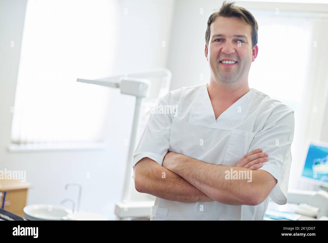 Your teeth look great. Portrait of a male dentist standing by the ...