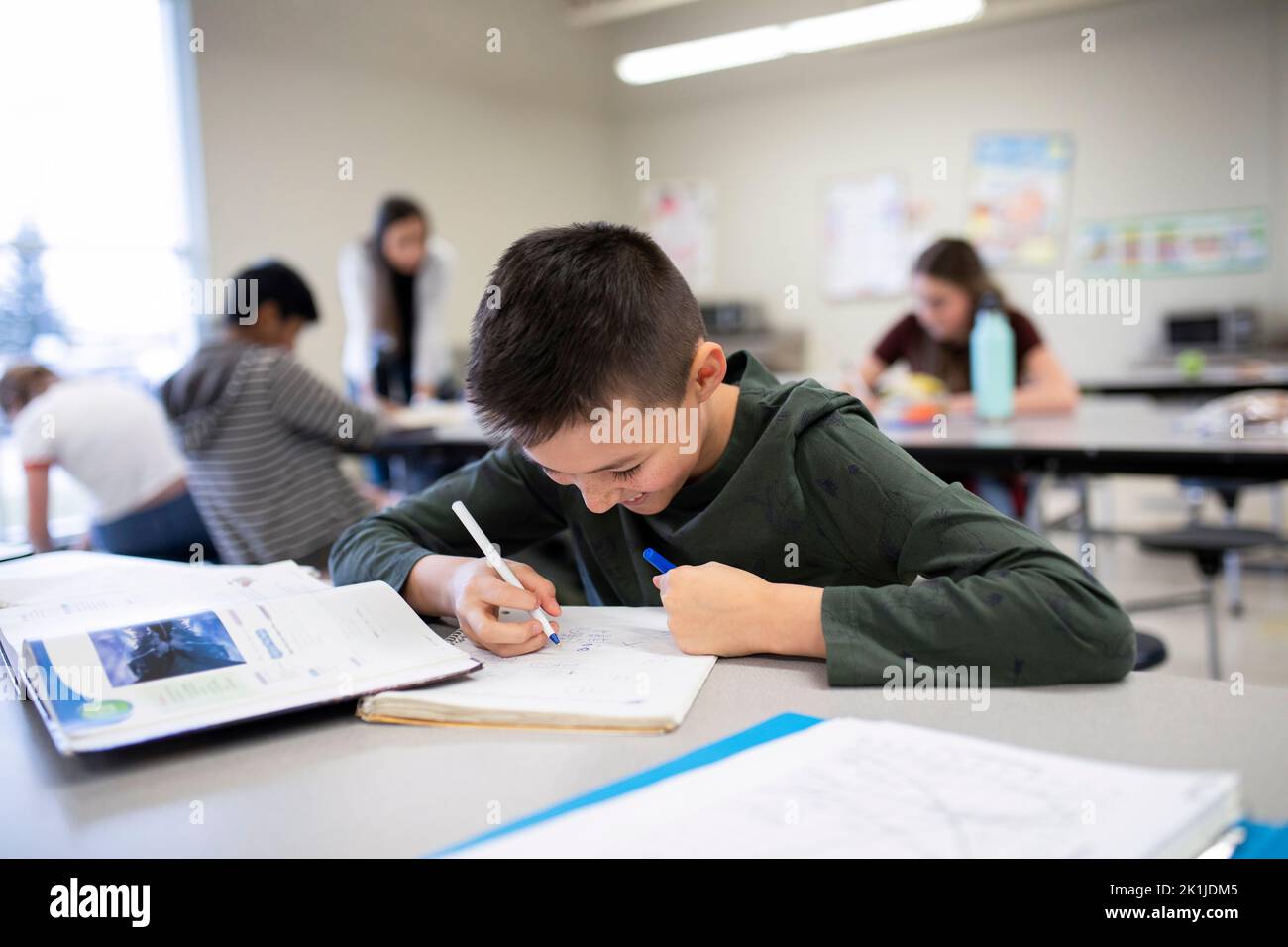 Boy in classroom writing hi-res stock photography and images - Alamy