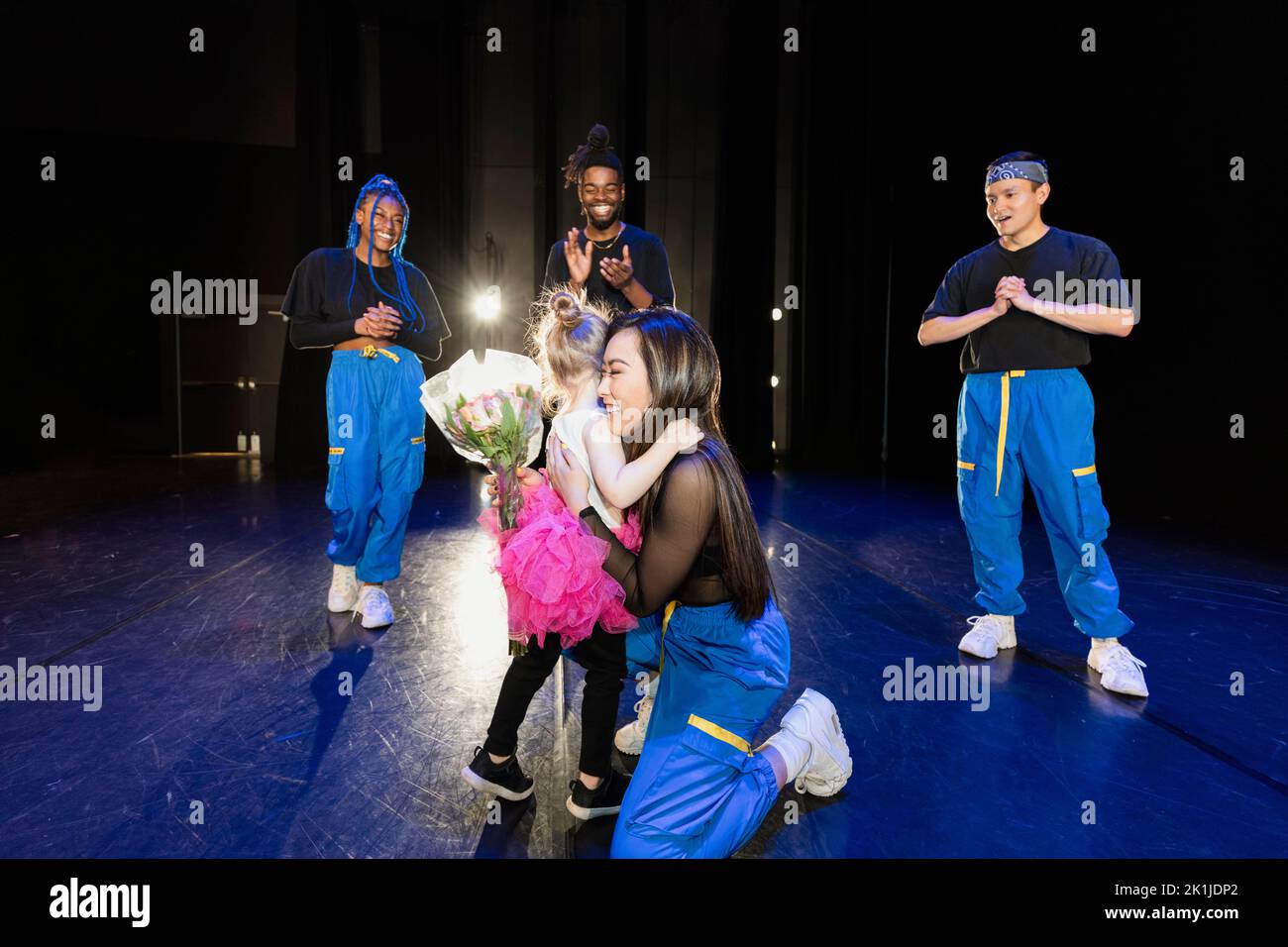 Cute girl ballerina giving flowers to hip-hop dancer on stage Stock ...