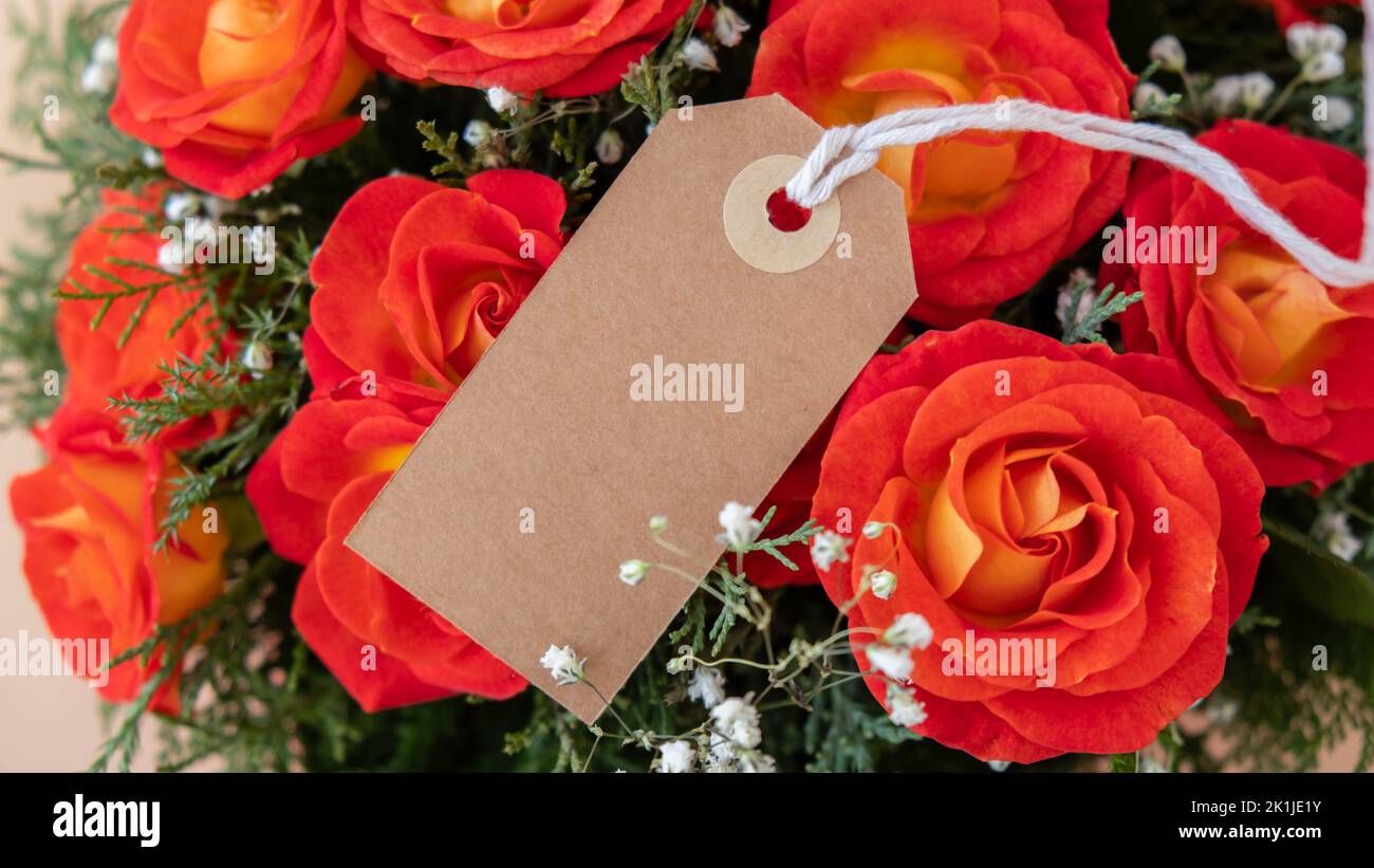 Bouquet of red roses with empty paper note copy space decorated in hat ...