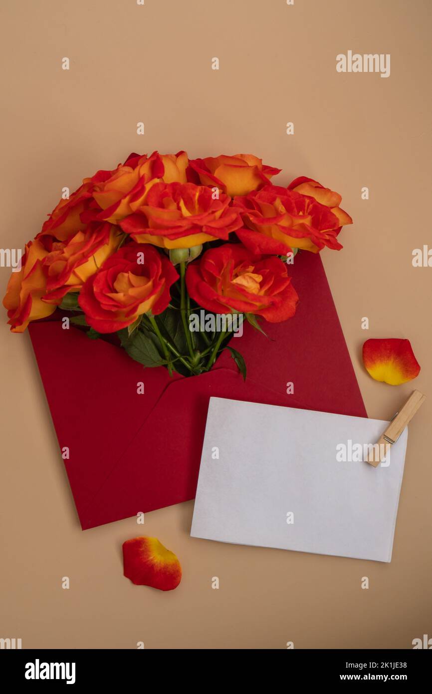 Beautiful red roses flowers in red postal envelope on neutral beige ...