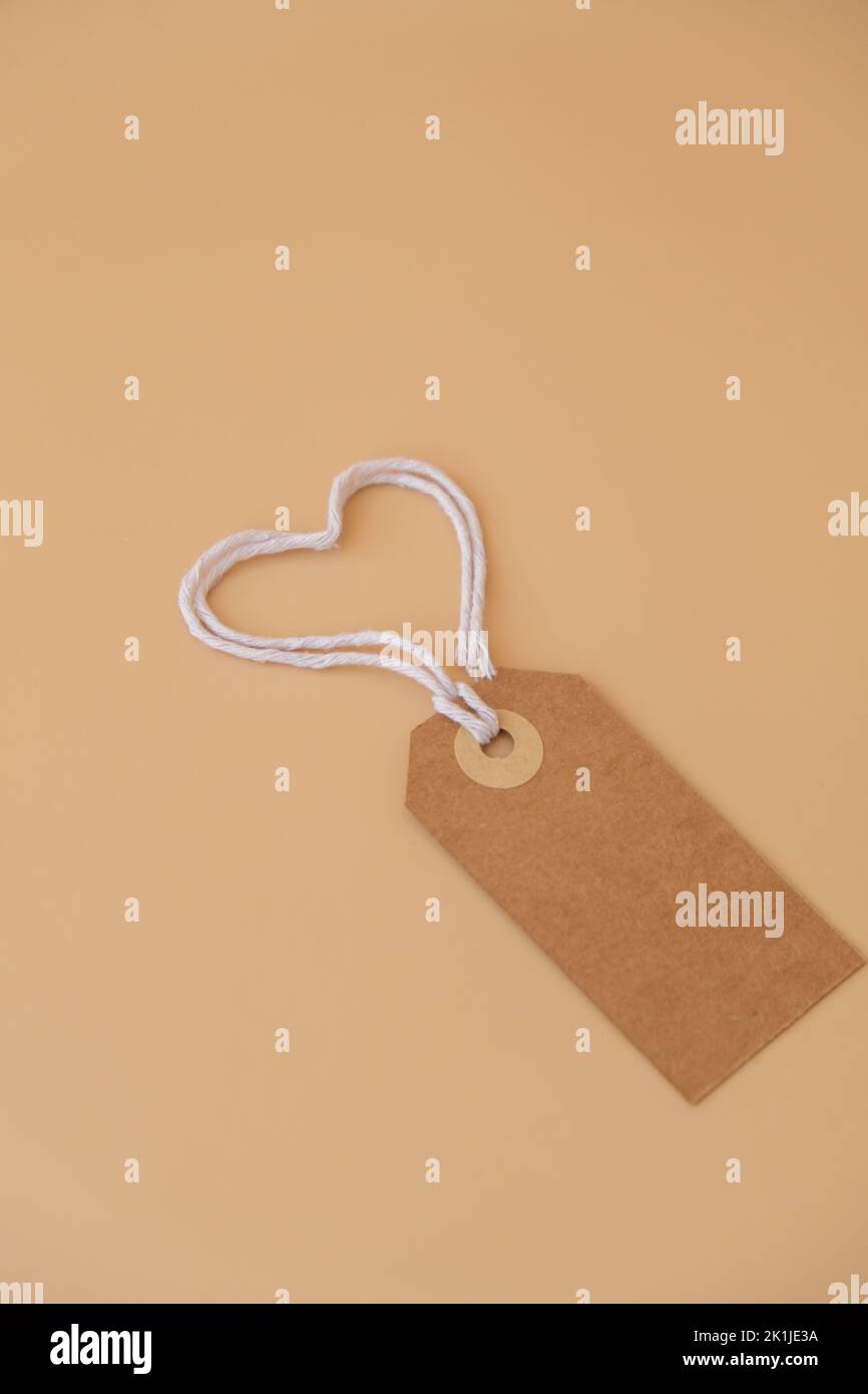 Monochrome beige paper note and rope in heart shape on neutral beige ...