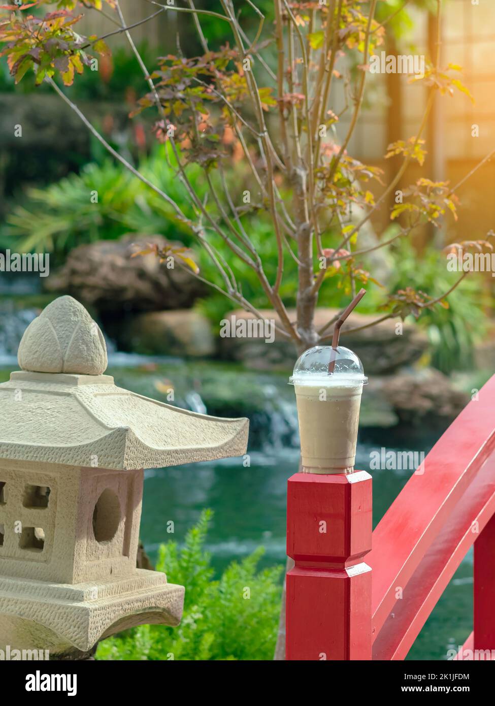 Iced cappuccino with straws placed on head of red wooden bridge in ...