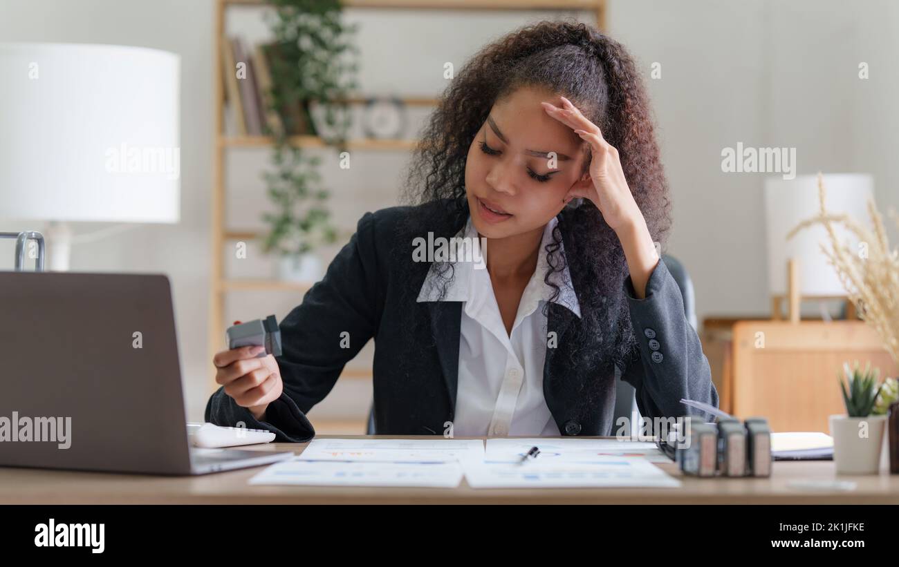Stressed Asian business woman worry with many document on desk at ...