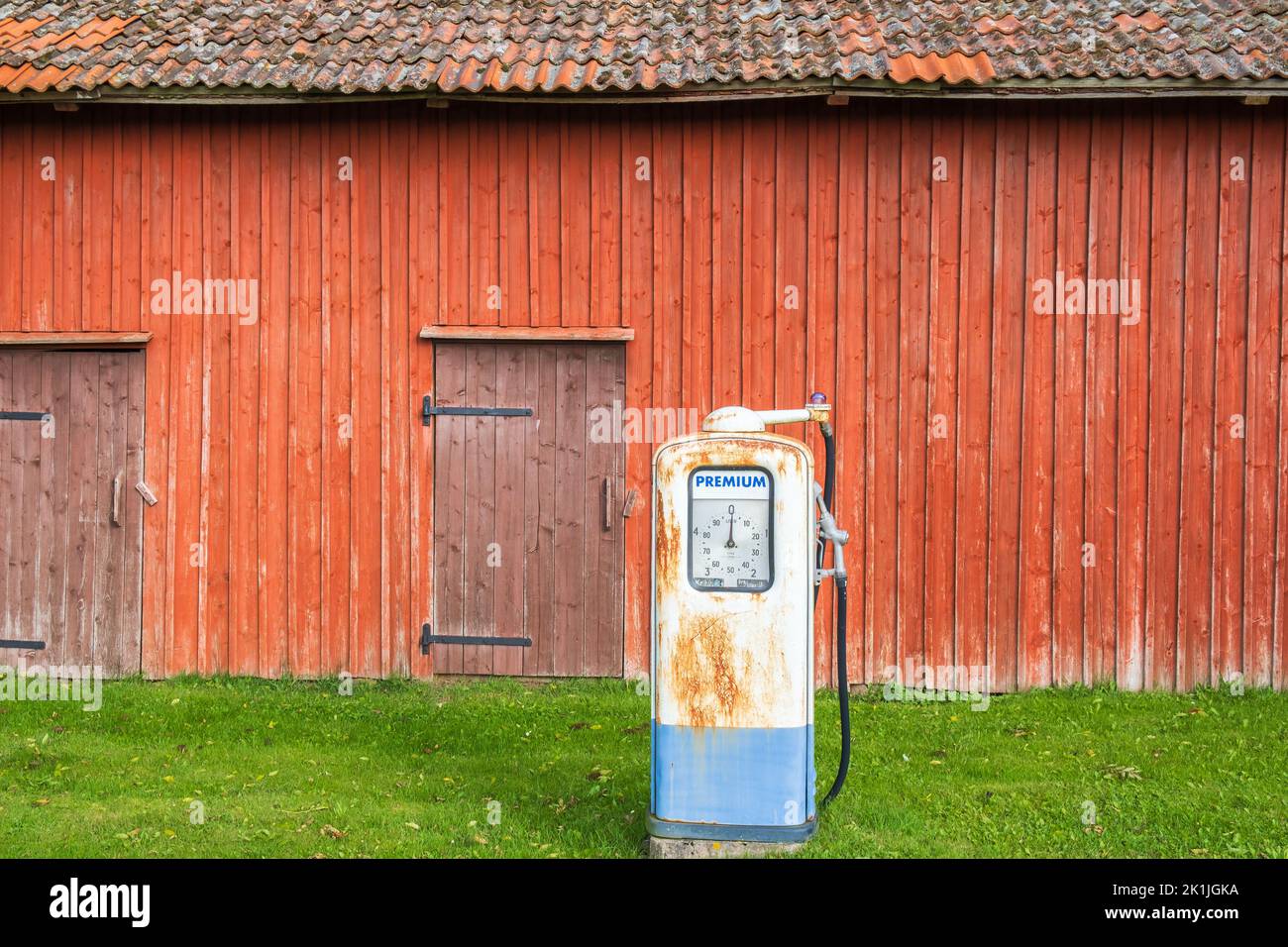 Old rusty petrol pump by a red barn in the countryside Stock Photo - Alamy