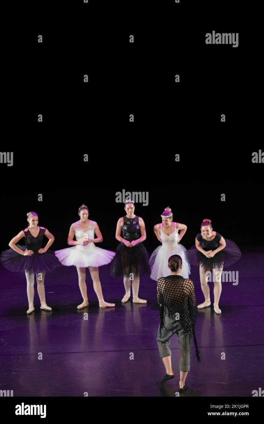 Female coach talking with ballerinas on stage Stock Photo - Alamy