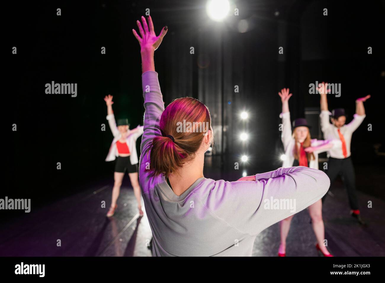 Female dance instructor guiding jazz dancers on stage Stock Photo - Alamy