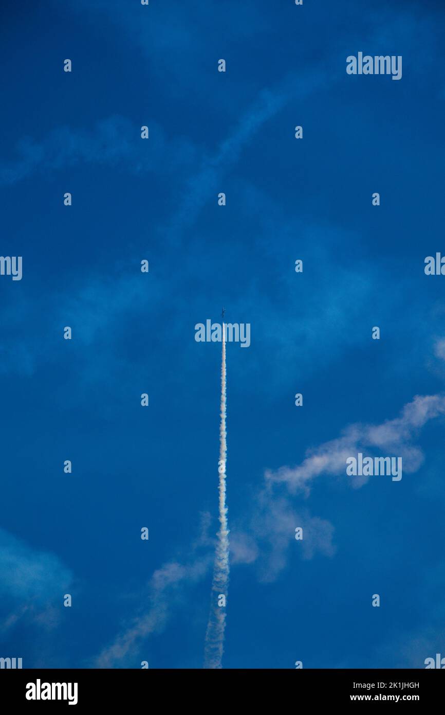 A vertical shot of contrail plain with a line-shaped cloud formation on ...