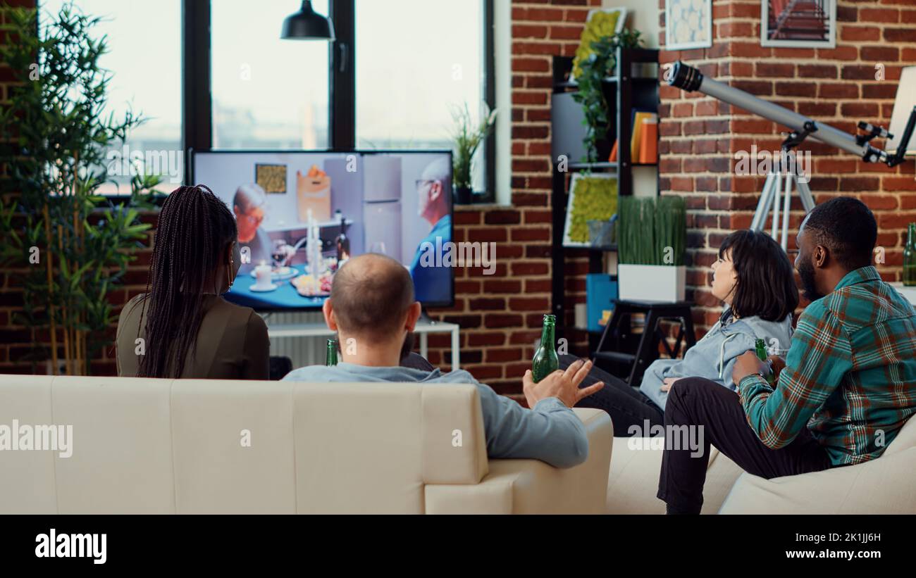 Multiethnic group of friends watching drama film on tv, enjoying movie ...