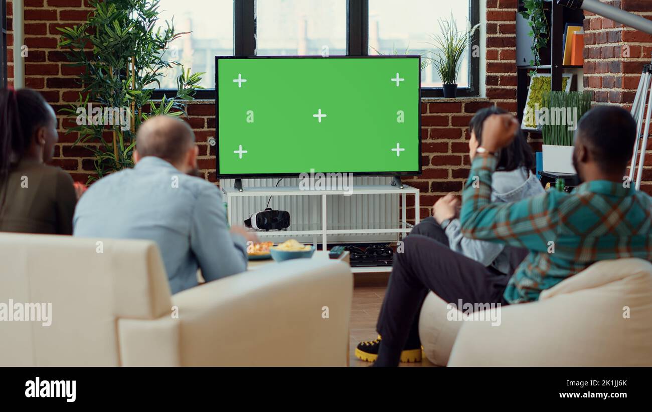 People cheering at football game match on greenscreen, using blank chroma key template to watch ...