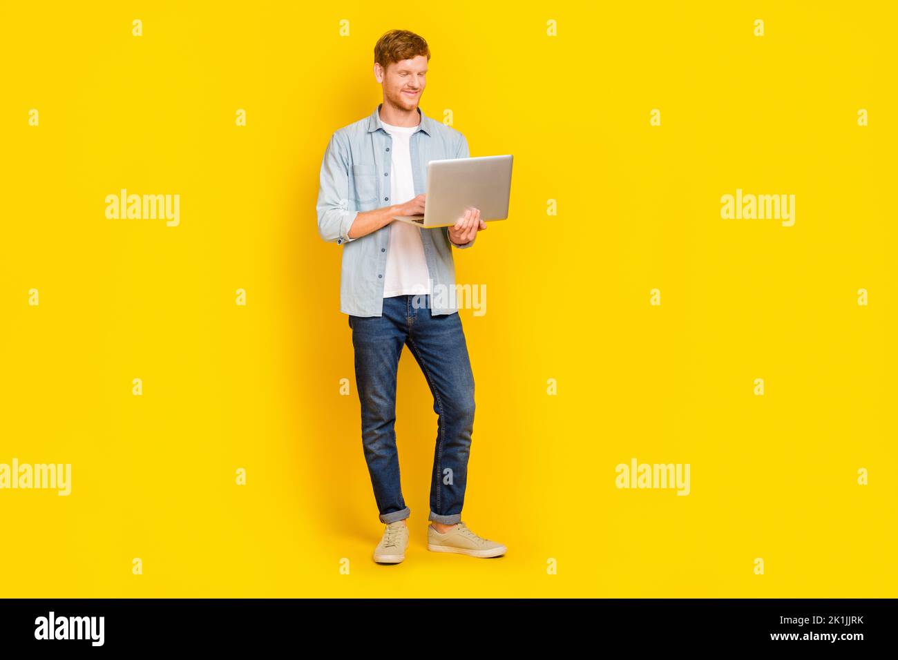 Photo of pretty attractive guy dressed denim shirt typing modern device ...