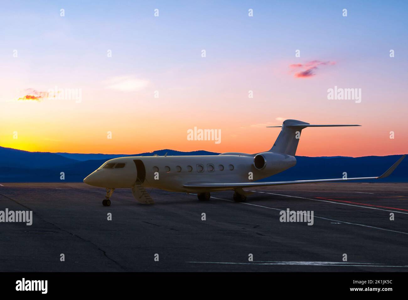 Modern white private jet with an opened gangway at the airport apron on ...