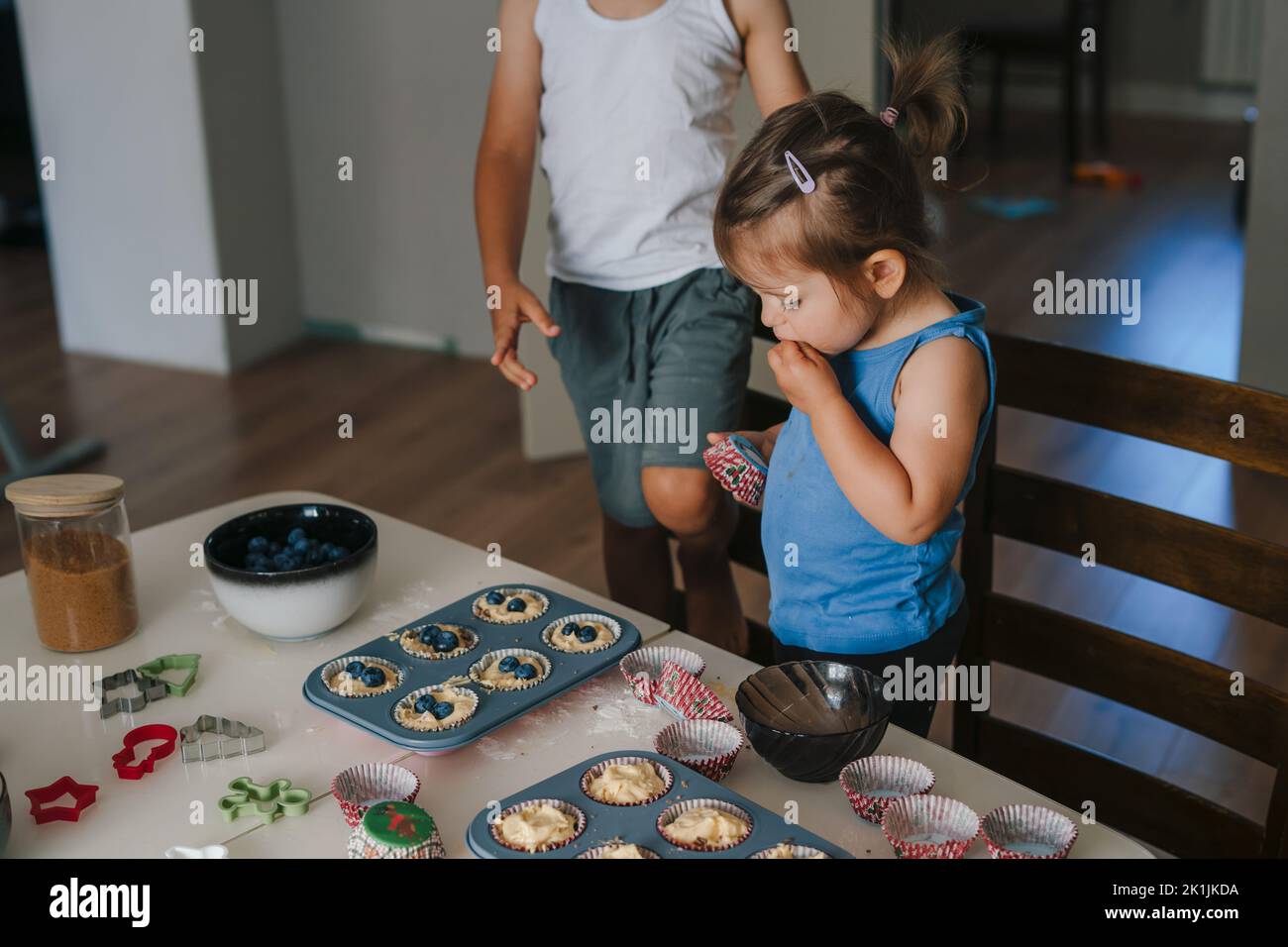 Happy family with two children making and decorating cupcakes with ...