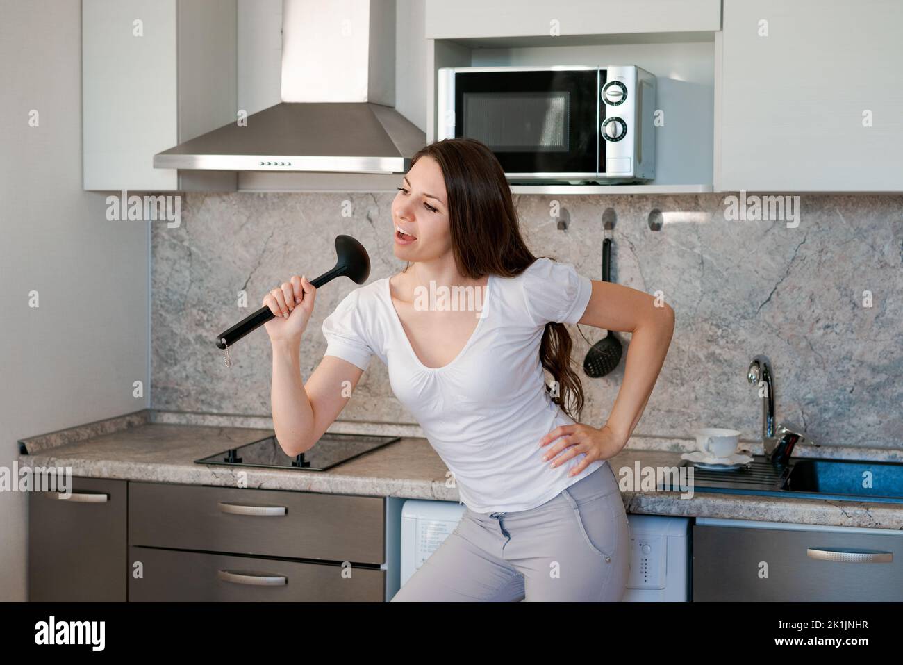 Photo young woman starting to prepare a family dinner, singing like a ...