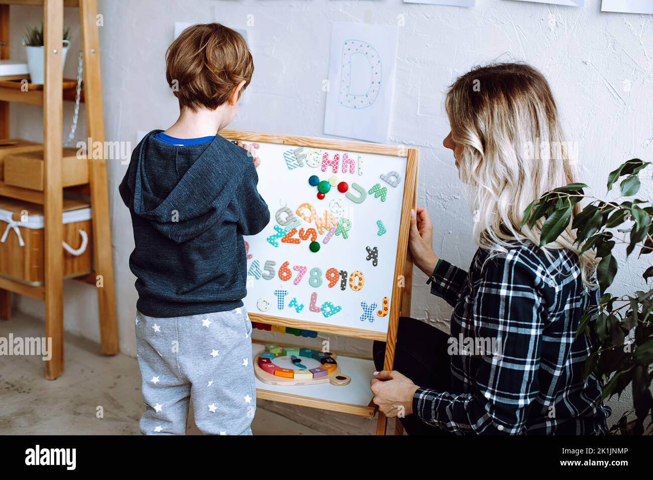 Kindergartener stand with back and learn english letters, alphabet and ...