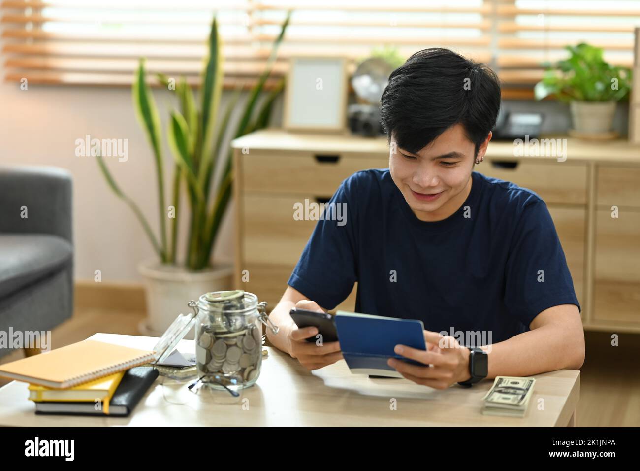 Satisfied asian man using smart phone for making online payments ...