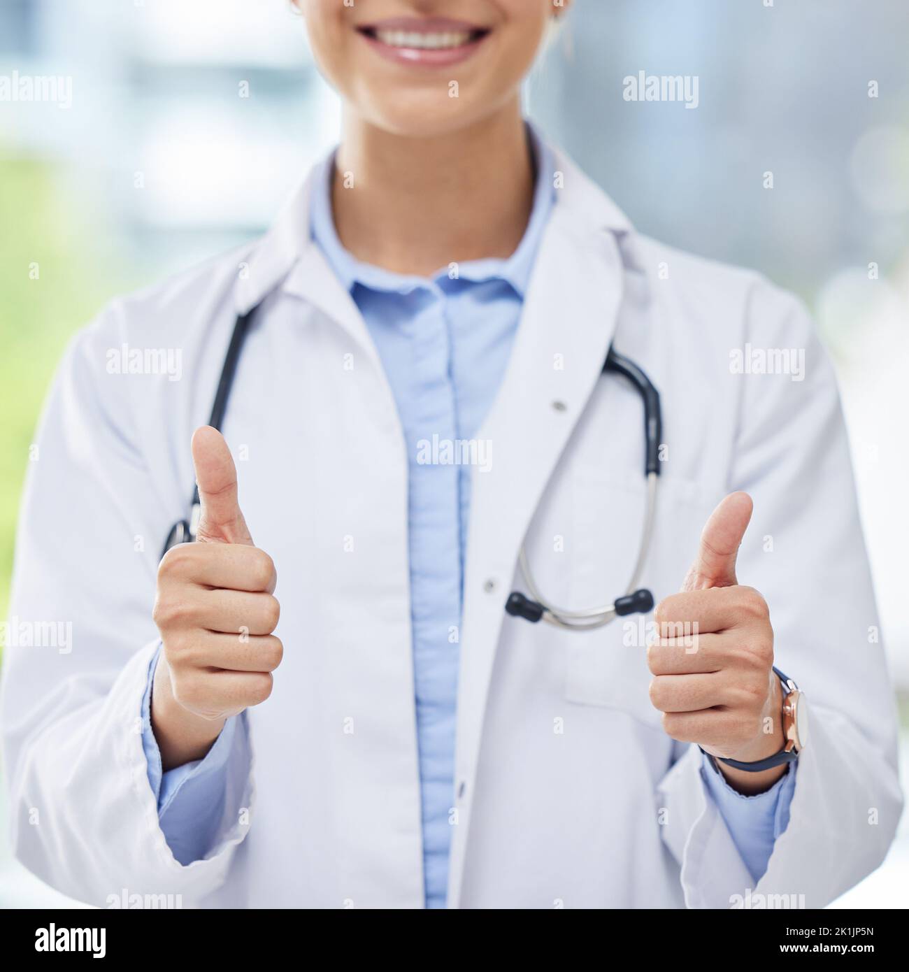 Healthcare, woman and thumbs up from doctor with a smile and blurred ...