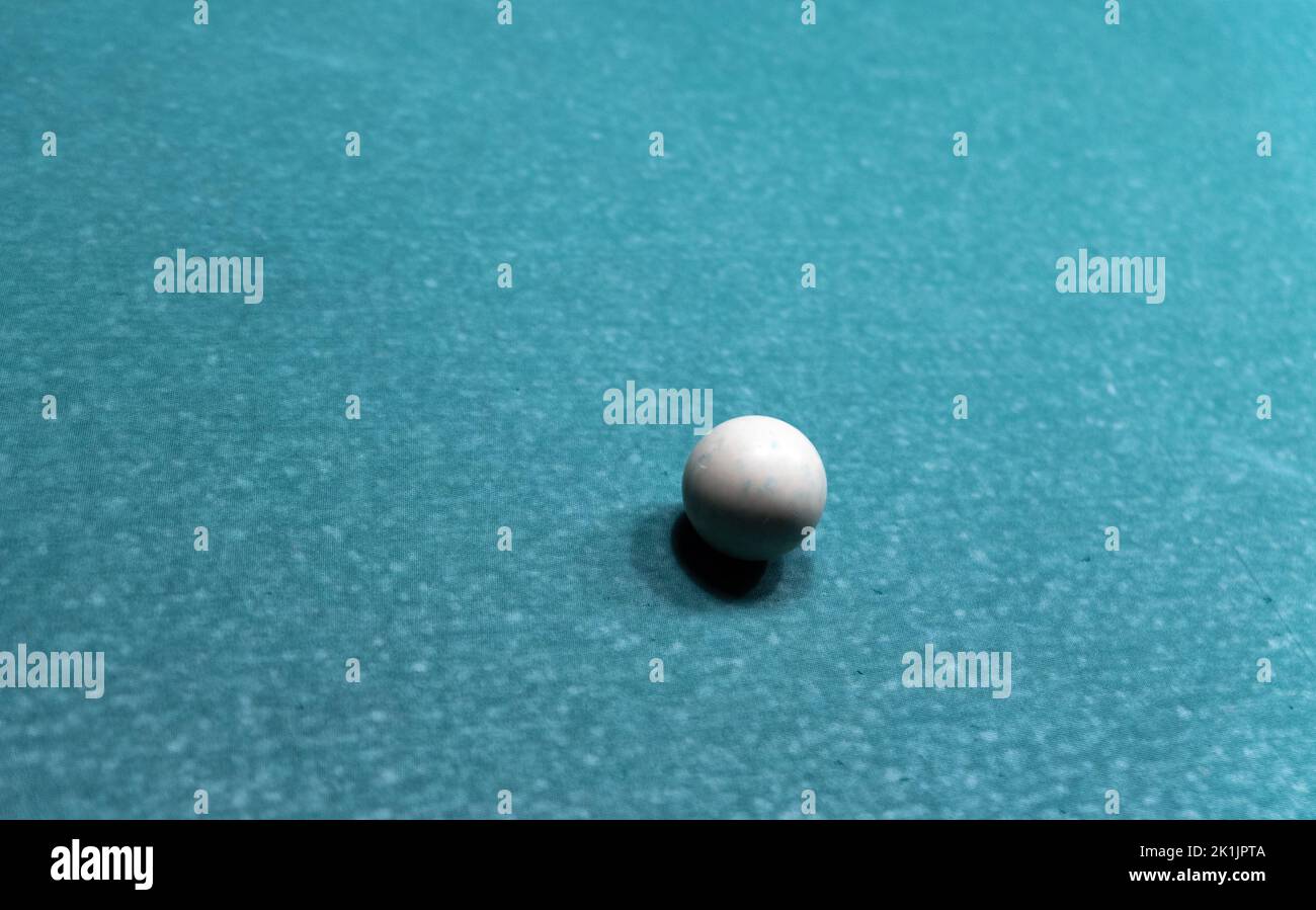 Cue ball on a worn out old pool table. A game of pool with used ...