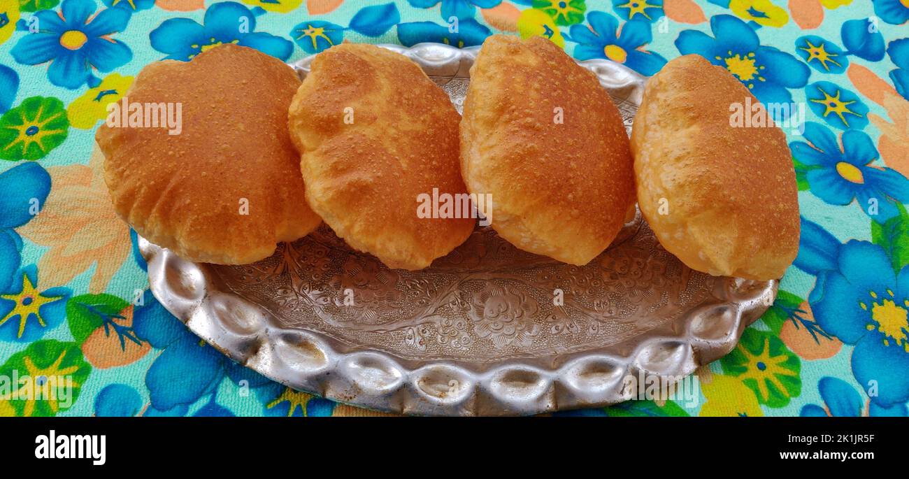 Indian traditional food puri or poori fried roti in blur bokeh ...