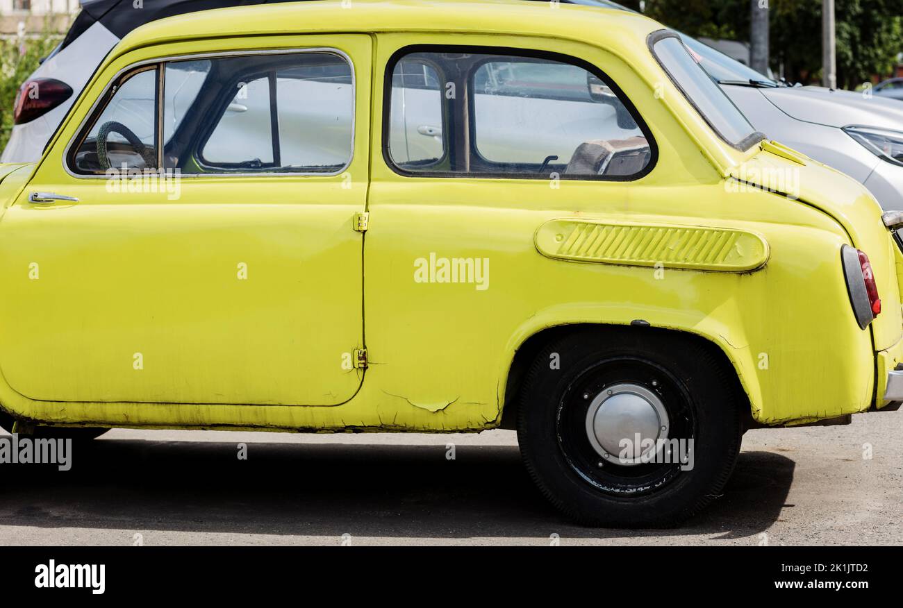 Old fashioned car parked in the street. Old yellow car Stock Photo - Alamy